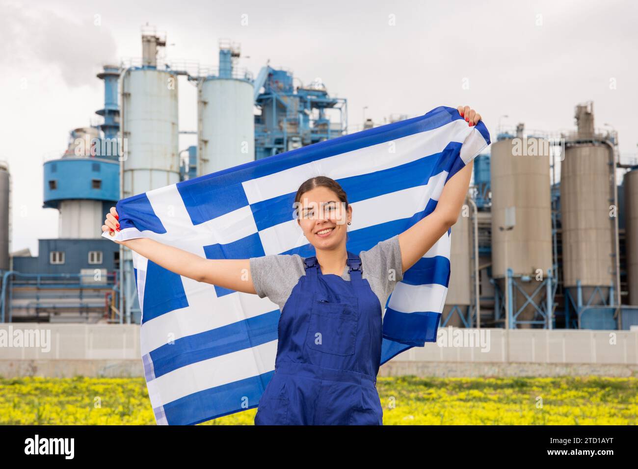 Happy young woman worker with flag of Greece against background of ...