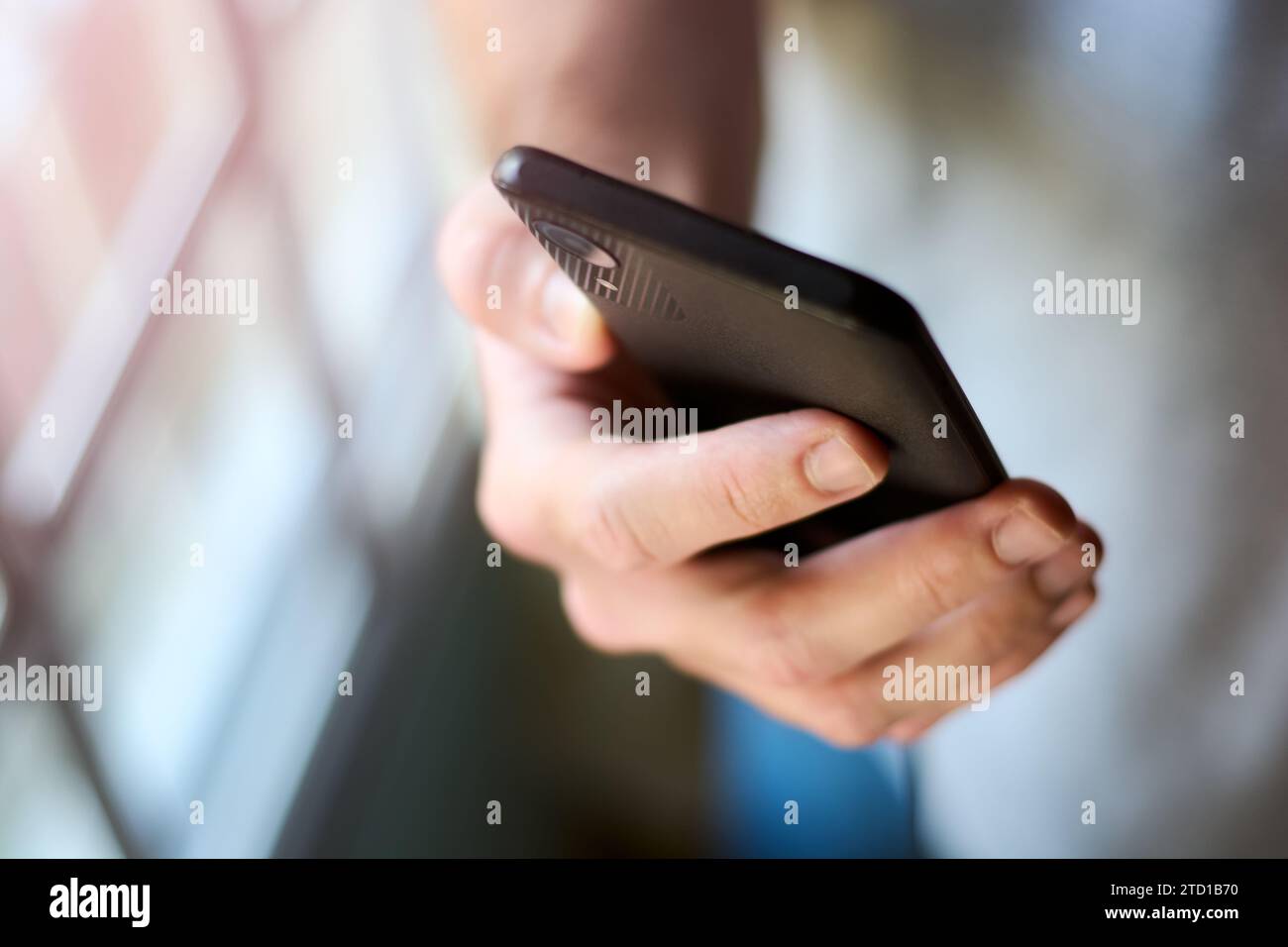 Close up of male hand holding mobile phone with selective focus, narrow ...
