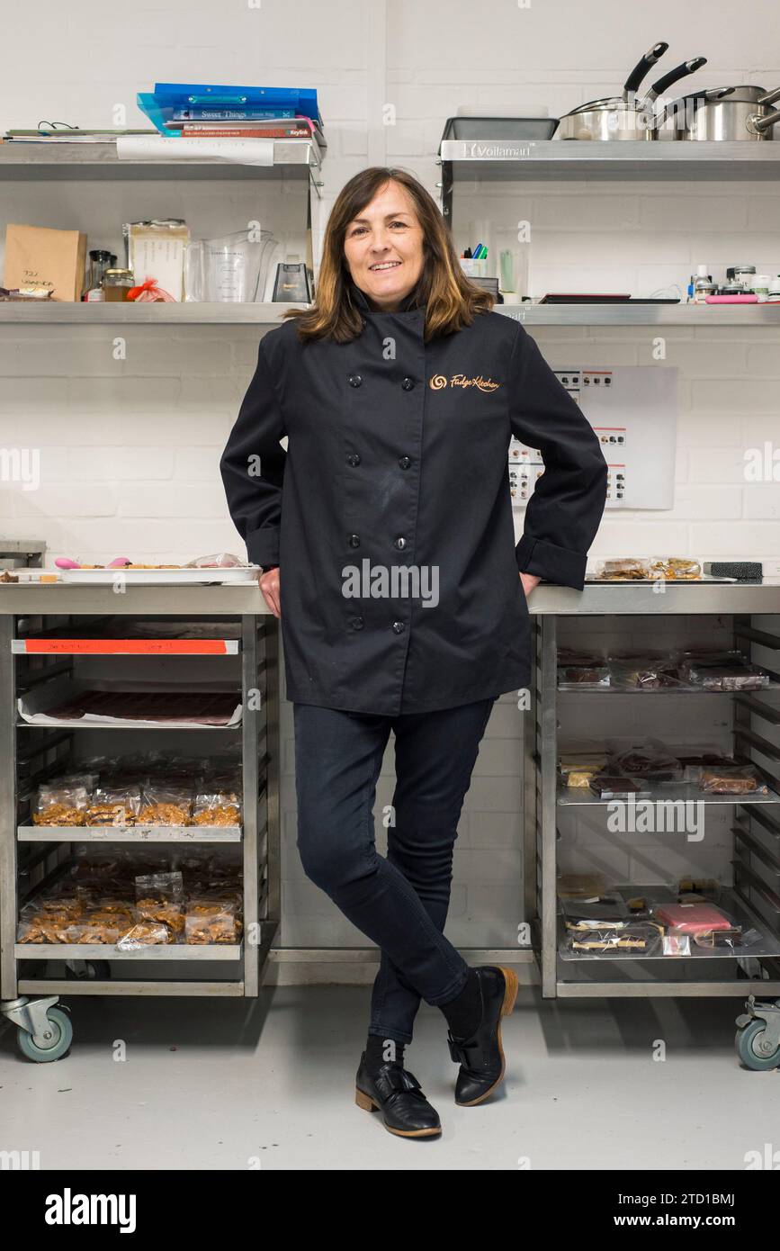 A female company owner poses for a portrait in her business premises ...