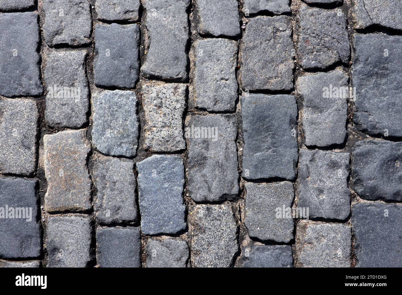 Dark grey cobblestone pavement from old smooth stones as background top ...