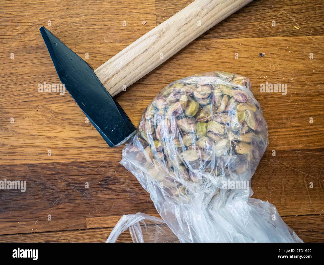 Crushing pistachios into powder breaking down with a hammer in a ...