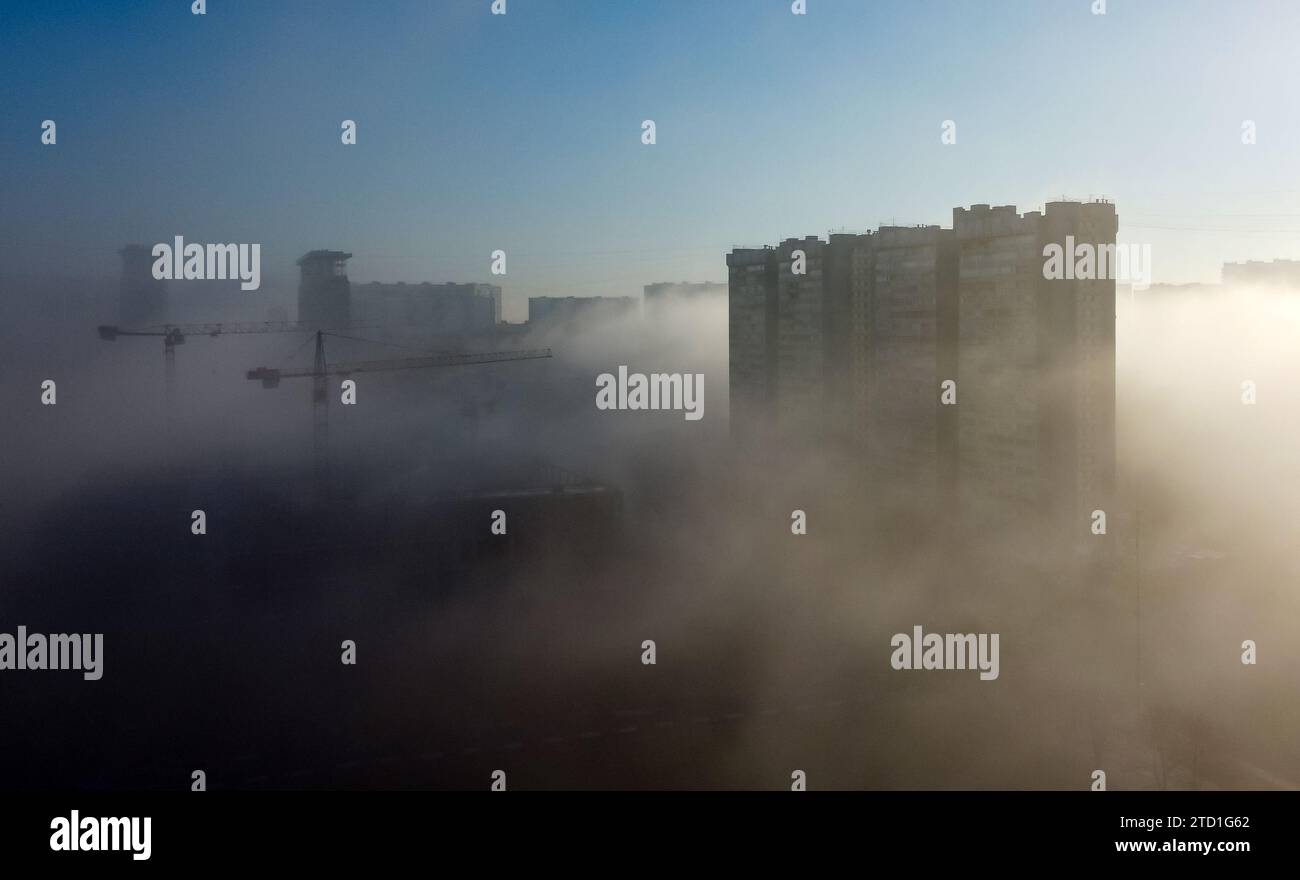 Construction cranes and a multi-storey residential building, shrouded ...