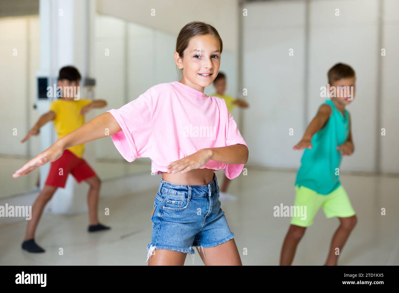 Happy tween girl dancing during group class in choreographic studio ...
