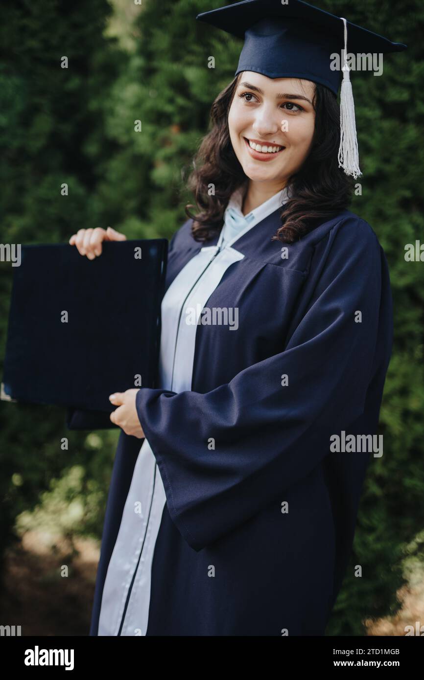 A girl in graduation gown and cap, celebrating her academic achievement ...