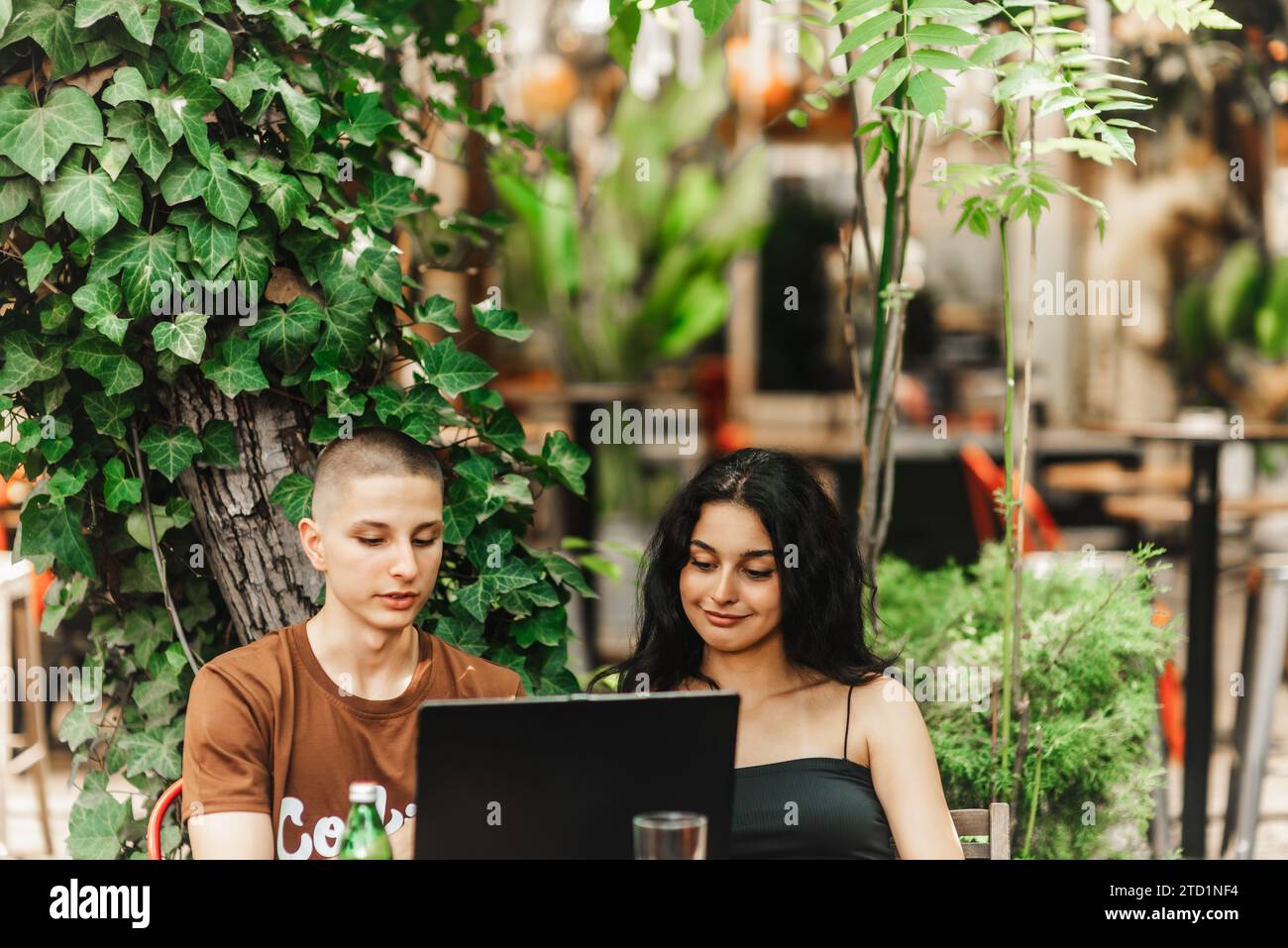 High school students gather at a cafe after classes, discussing and ...
