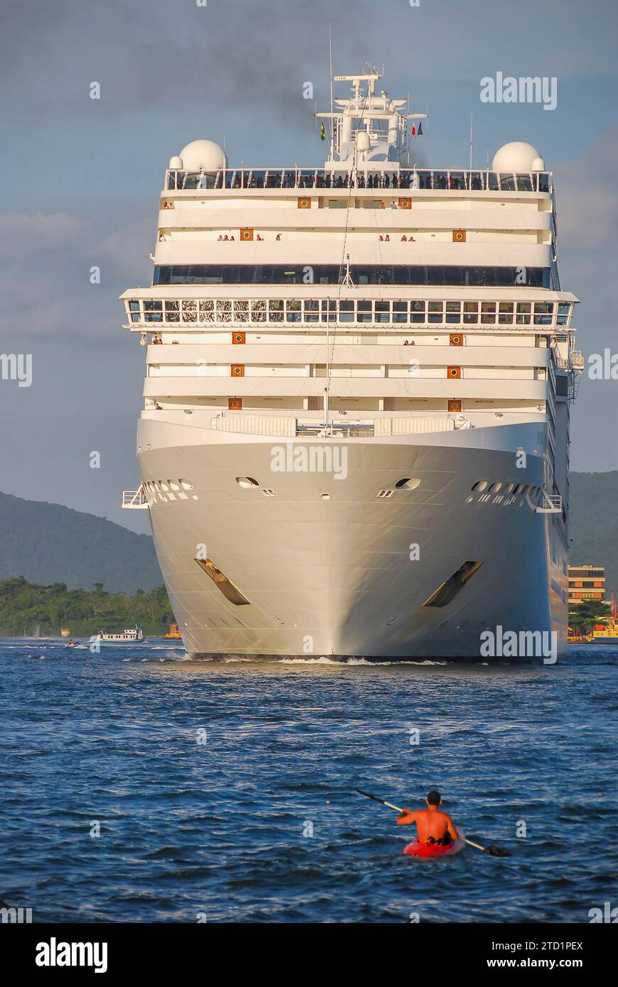 Cruise ship sailing during sunset. Man paddling kayak in front of the ...
