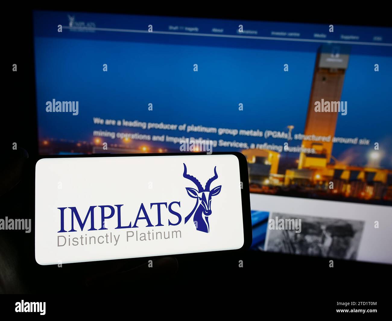 Person holding smartphone with logo of company Impala Platinum Holdings Limited (Implats) in ...