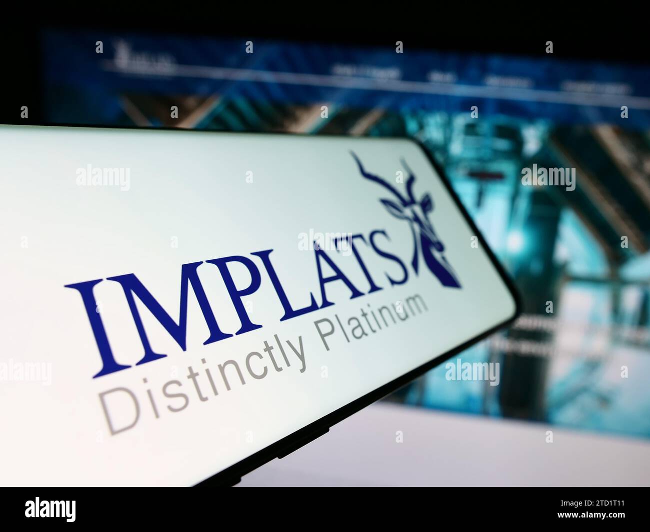 Cellphone with webpage of company Impala Platinum Holdings Limited (Implats) in front of logo ...