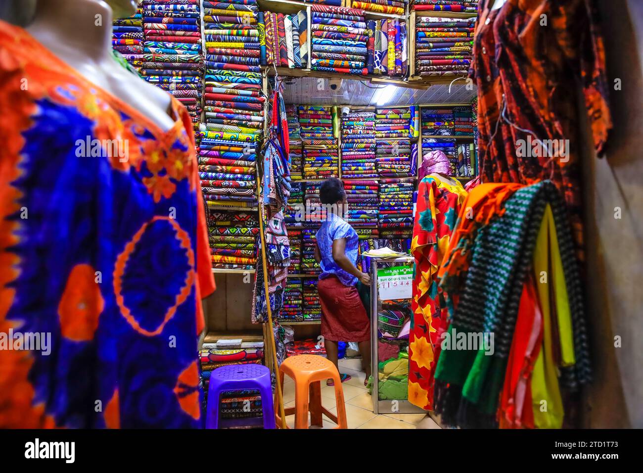 A trader is selling her fabric products at a textile shop in Biashara ...