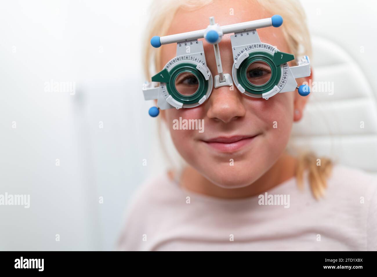 Young girl wearing trial frame glasses during an optometrist. having ...