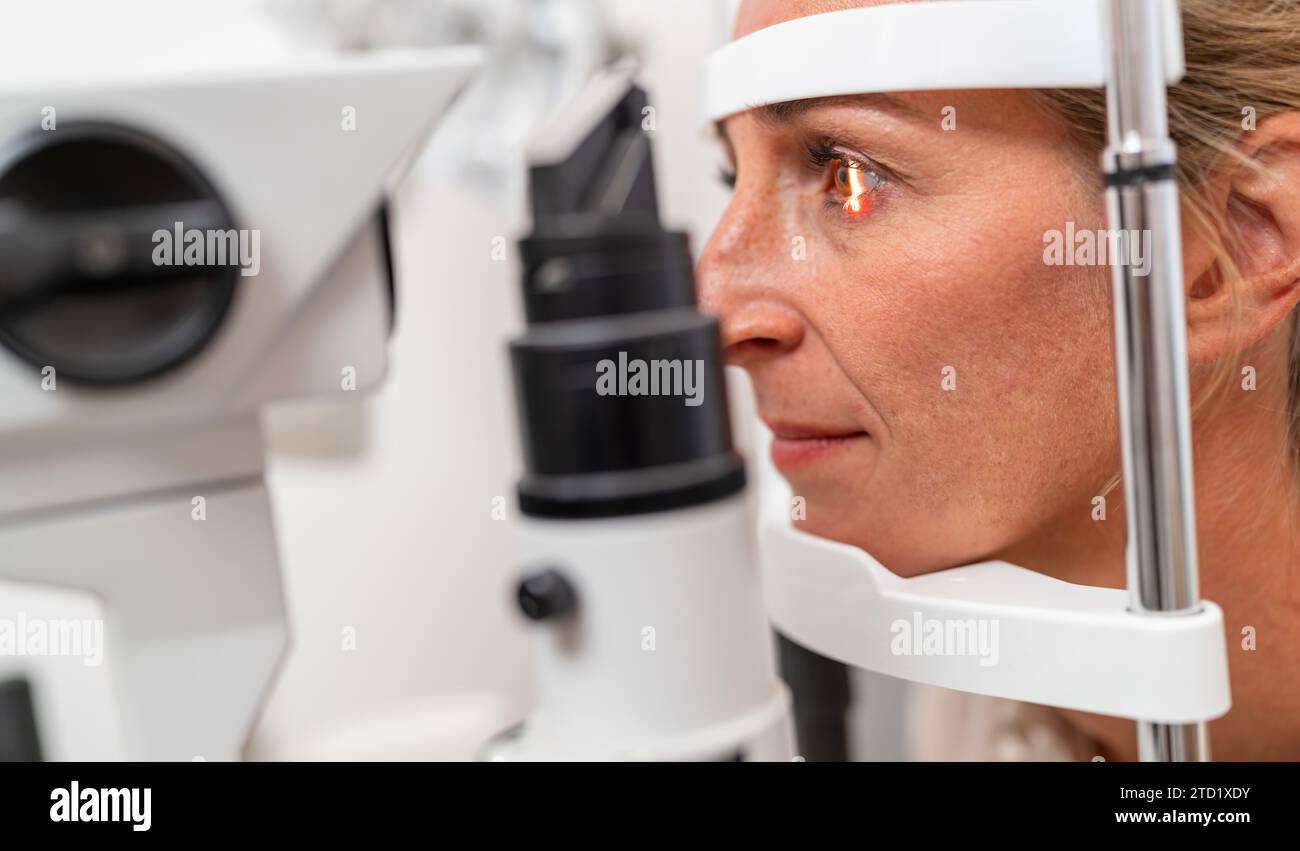Patient undergoing an eye examination with a focus on her illuminated ...
