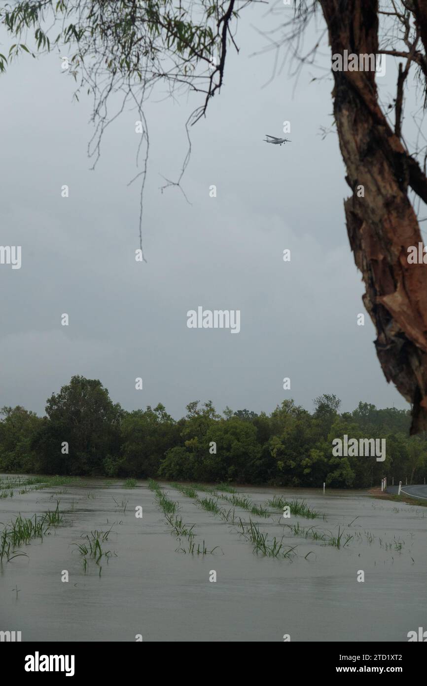 A light plane flies over a flooded field in the Cairns suburb of ...