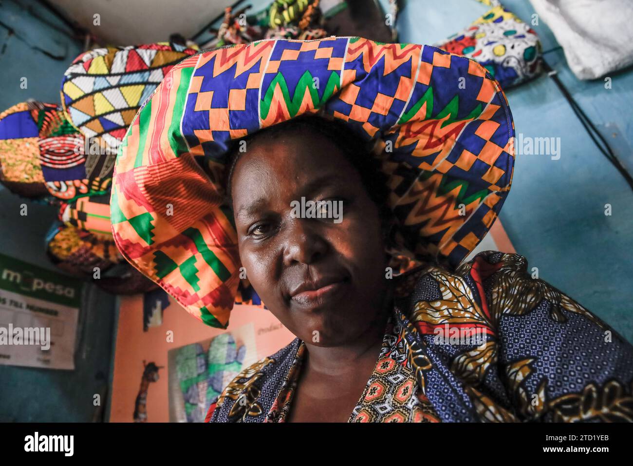 A portrait of Tabitha Achieng, a tailor from kibera paused inside her ... A portrait of Tabitha Achieng, a tailor from kibera paused inside her ...