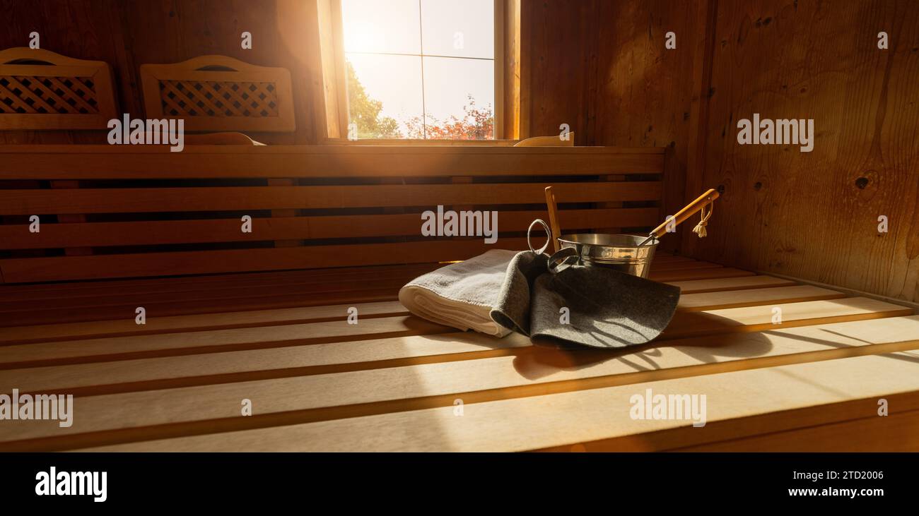 Wooden sauna with benches, window, towel, metal bucket, ladle, and felt ...