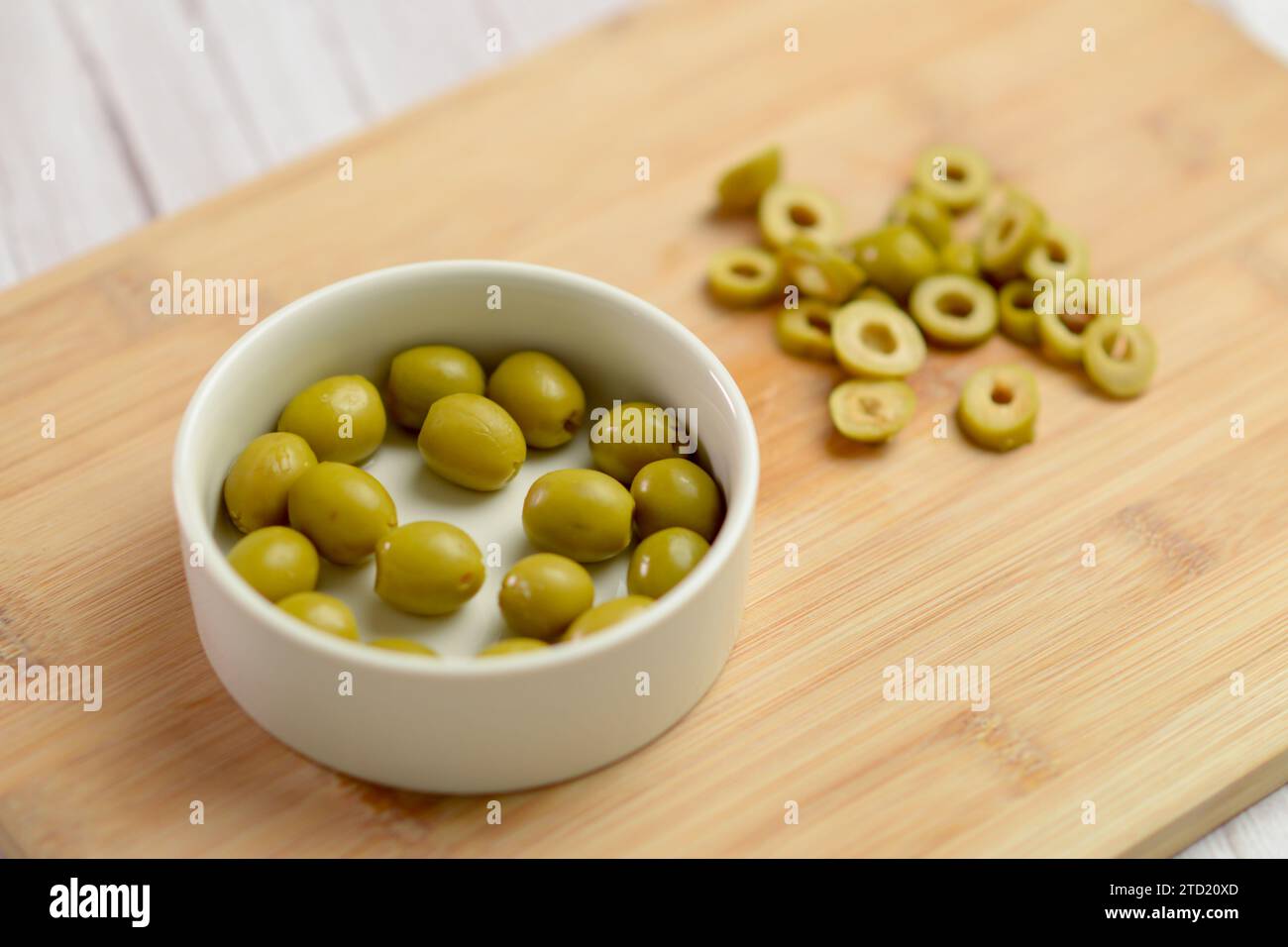 Cooking ingredients: Chopped green olives on wooden surface Stock Photo ...