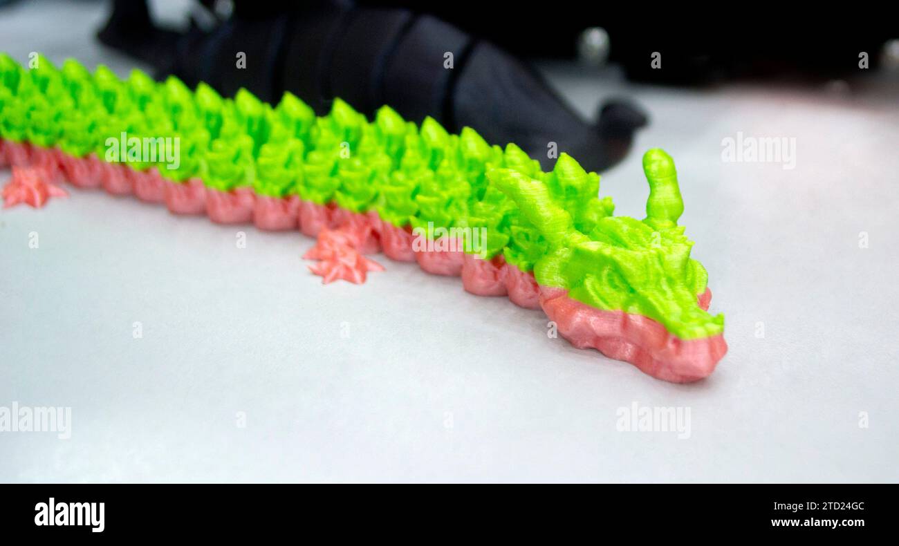 Prototype of pink green dragon 3D printed from melted plastic. Close-up ...