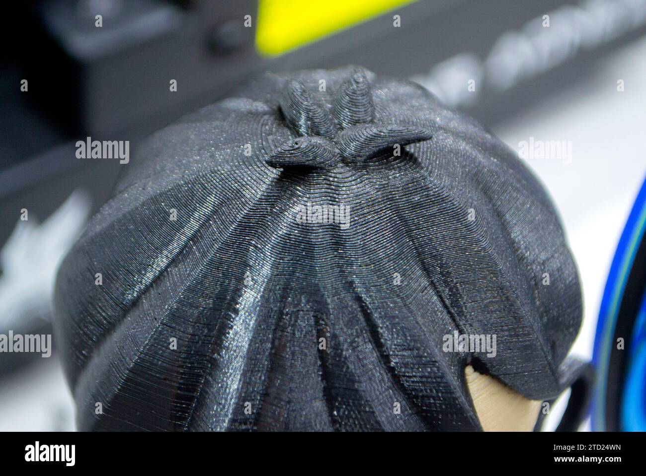 Prototype of head with black hair 3D printed from melted plastic. Close ...