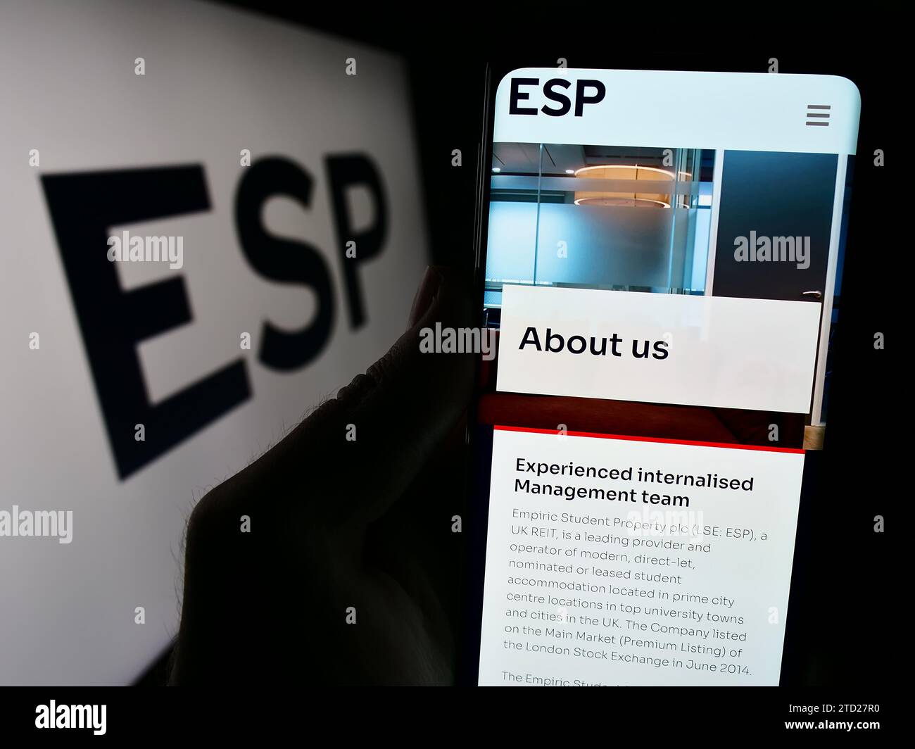 Person holding mobile phone with website of British company Empiric ...