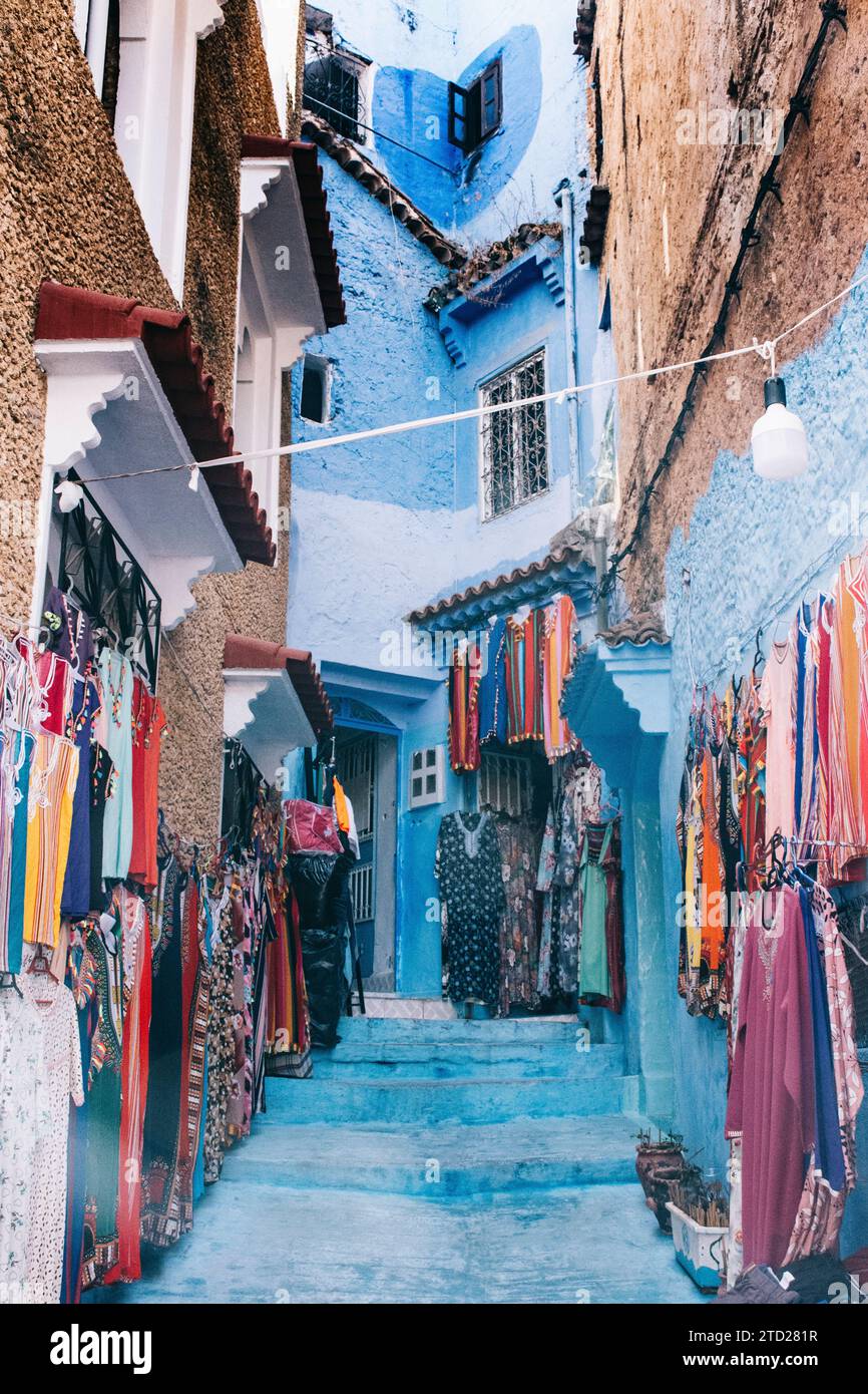 Typical blue painted street with clothing shops in the medina of ...