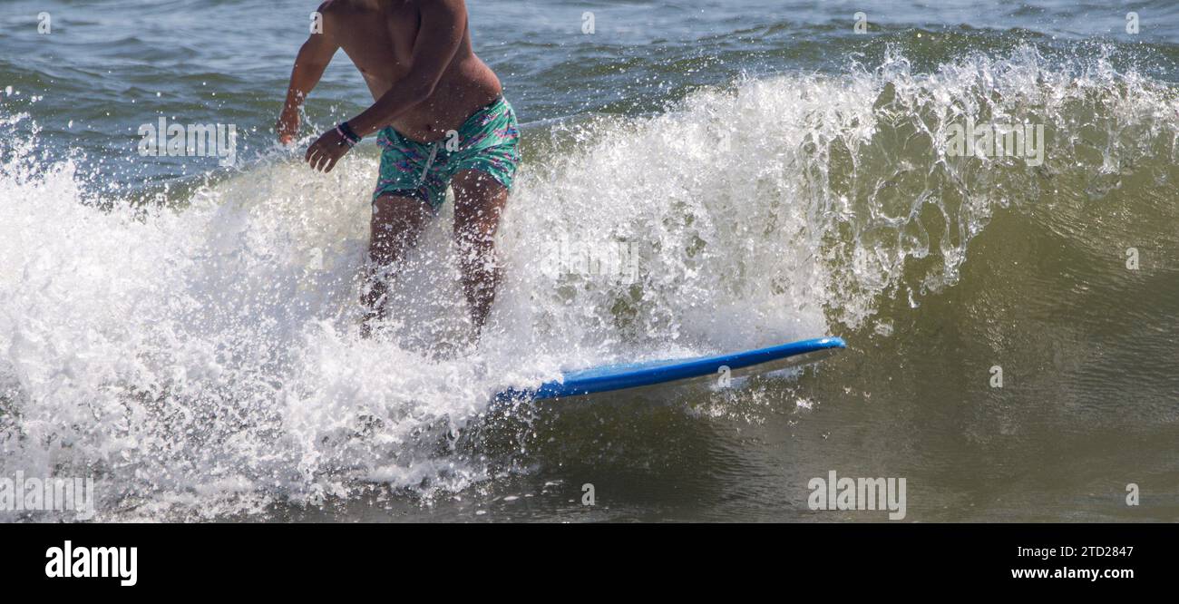 Man Surfing using a blue surboard at Gilgo Beach on Long Island Stock ...