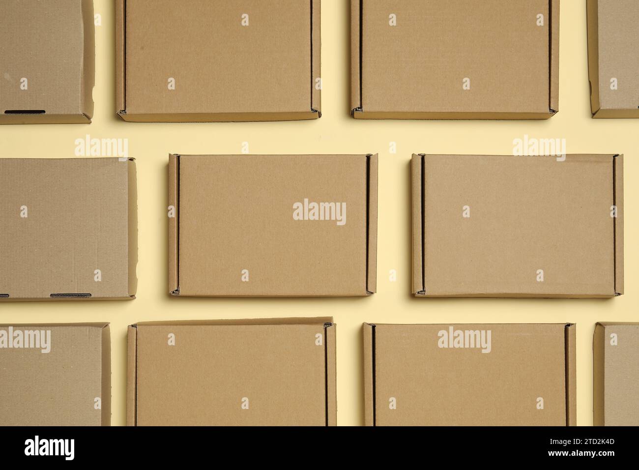 Many closed cardboard boxes on pale yellow background, flat lay Stock ...