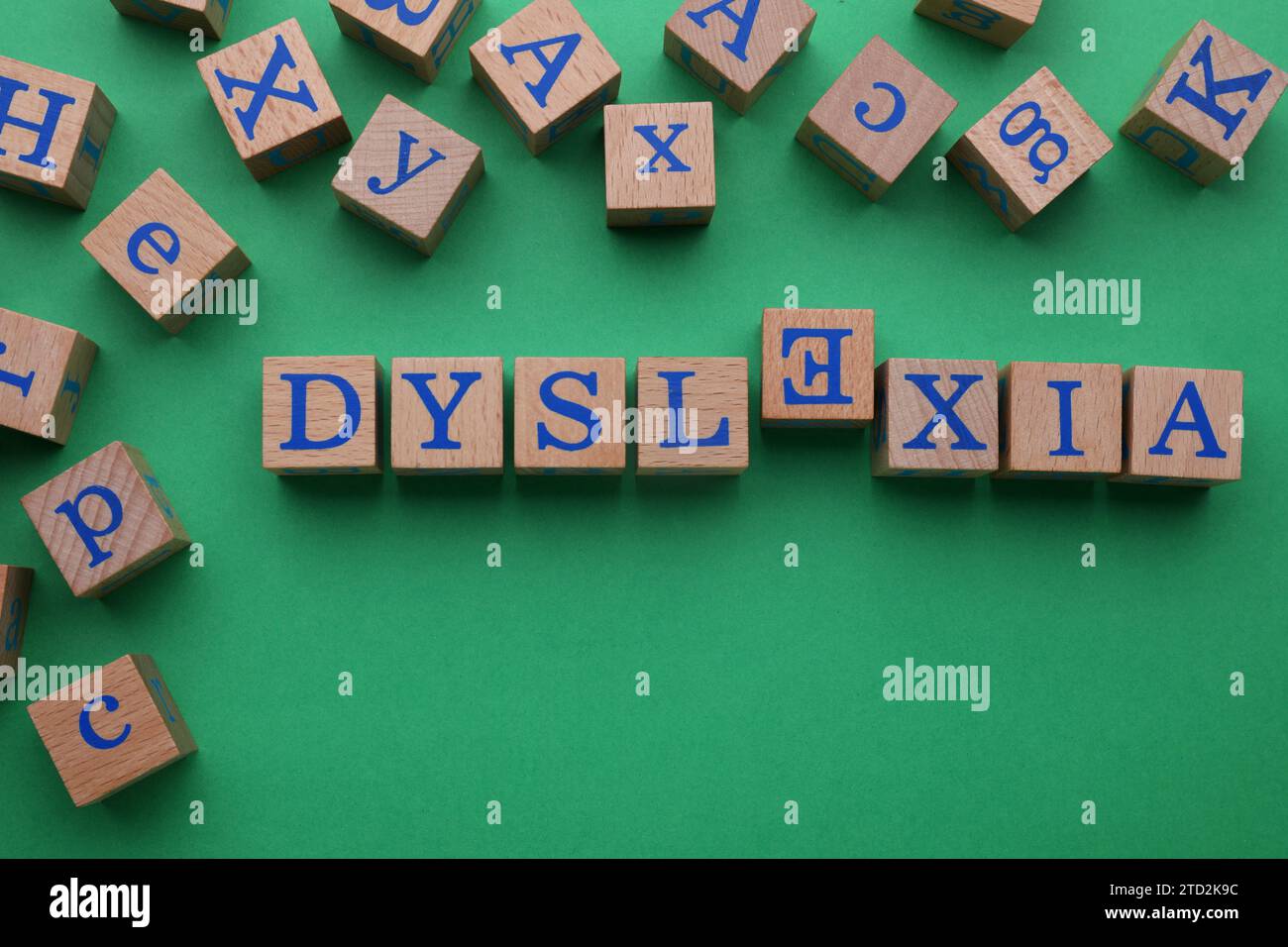 Word Dyslexia with inverted letter E of wooden cubes on green ...