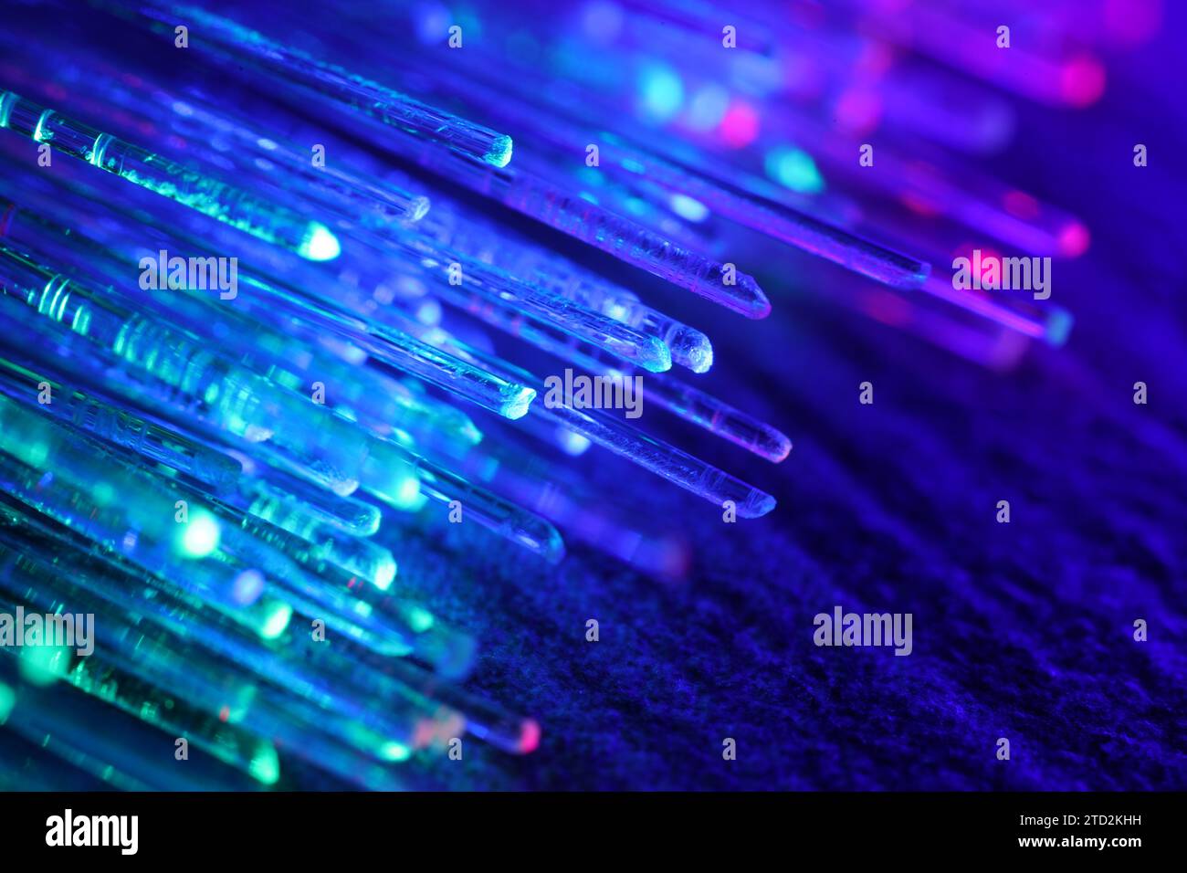 Optical fiber strands transmitting different color lights on dark ...