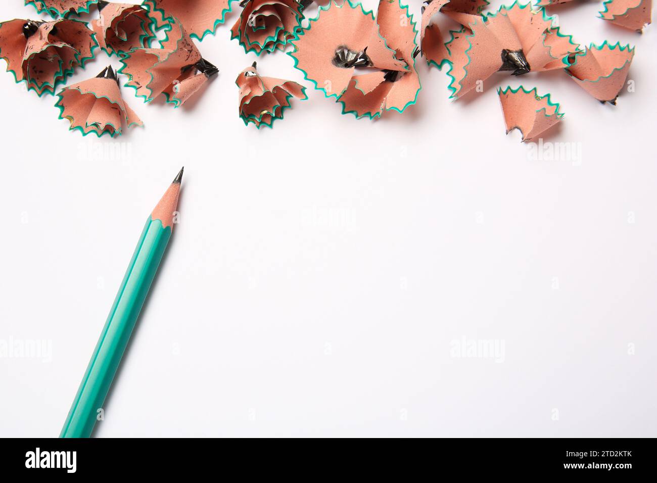 Sharp graphite pencil and shavings on white background, top view. Space ...