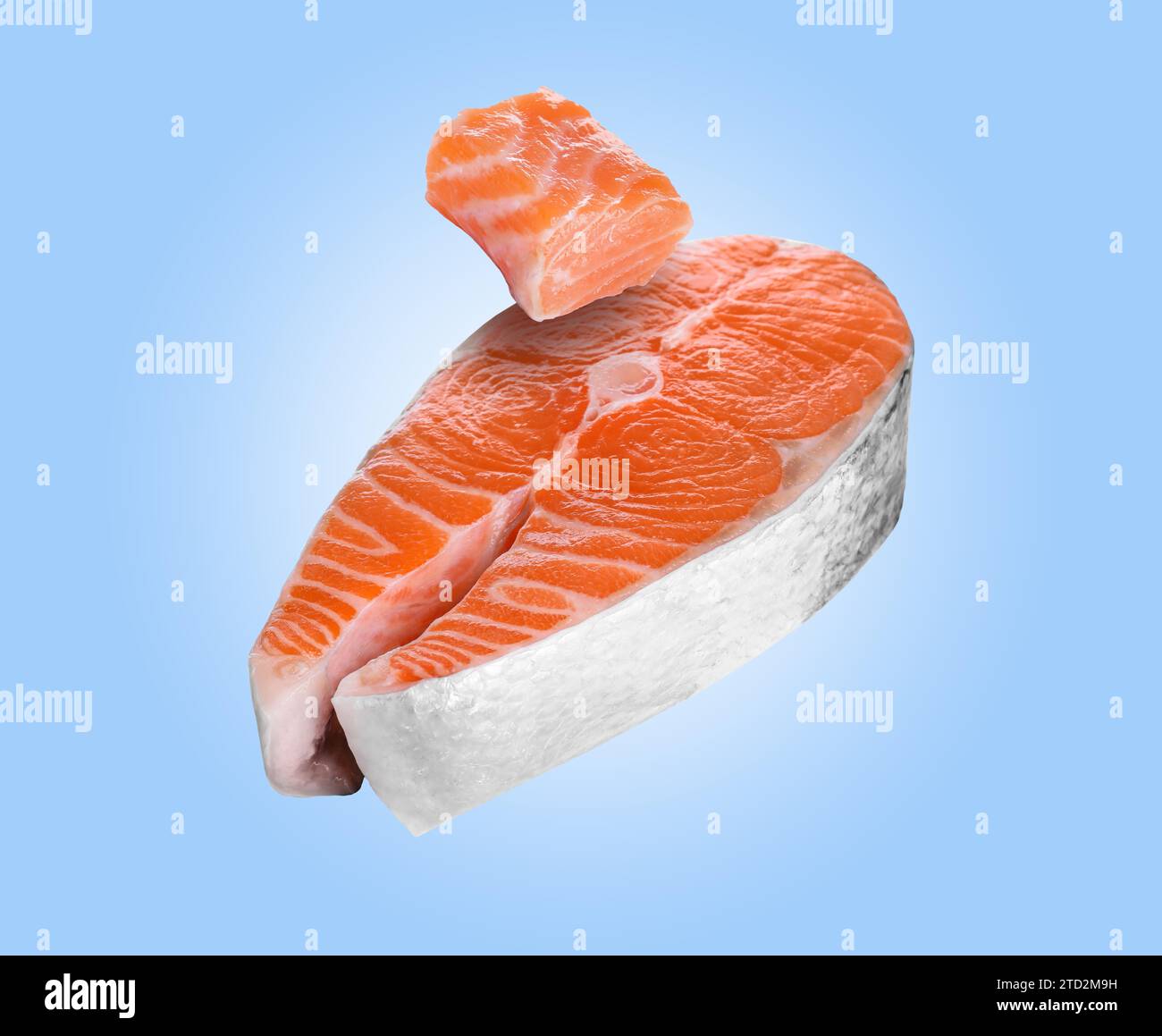 Fresh salmon steak and piece falling on light blue background Stock ...
