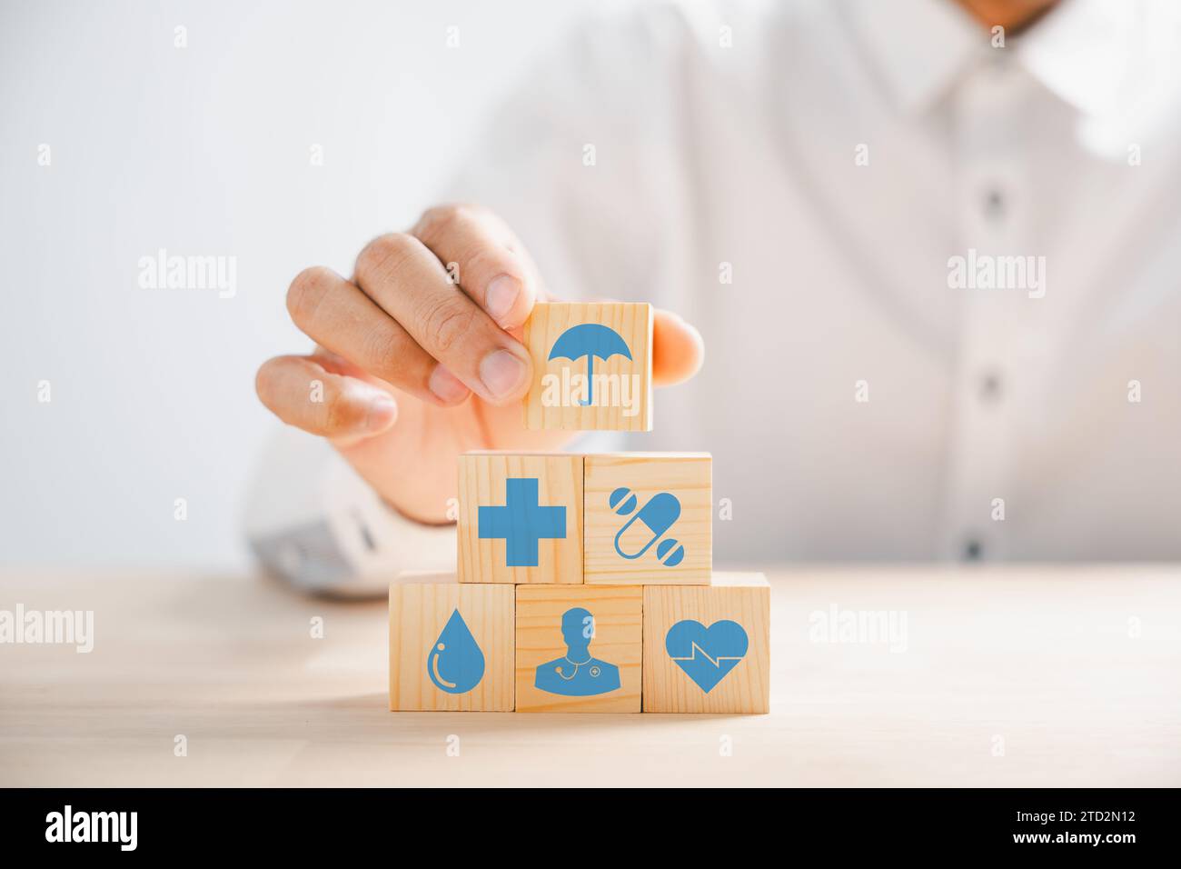 Hand hold wooden block with icon healthcare medical Stock Photo - Alamy