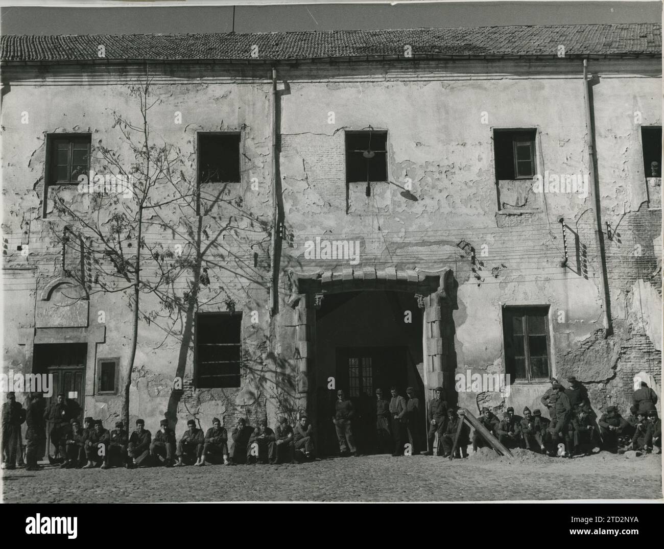 Madrid, 1962. Soldiers resting at the old door inside the Conde Duque ...