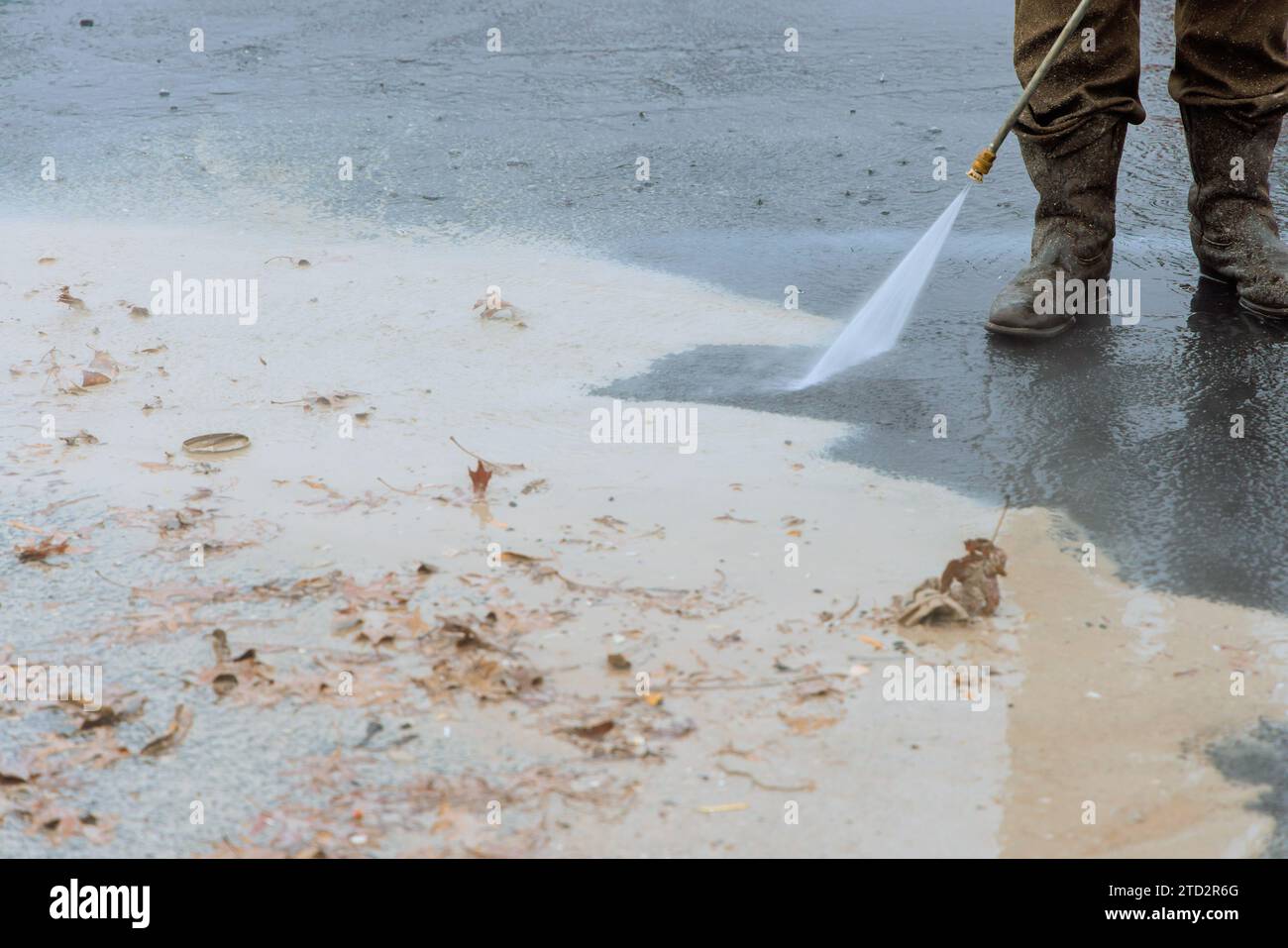 Pressurized water sprayed on street to clean it Stock Photo - Alamy
