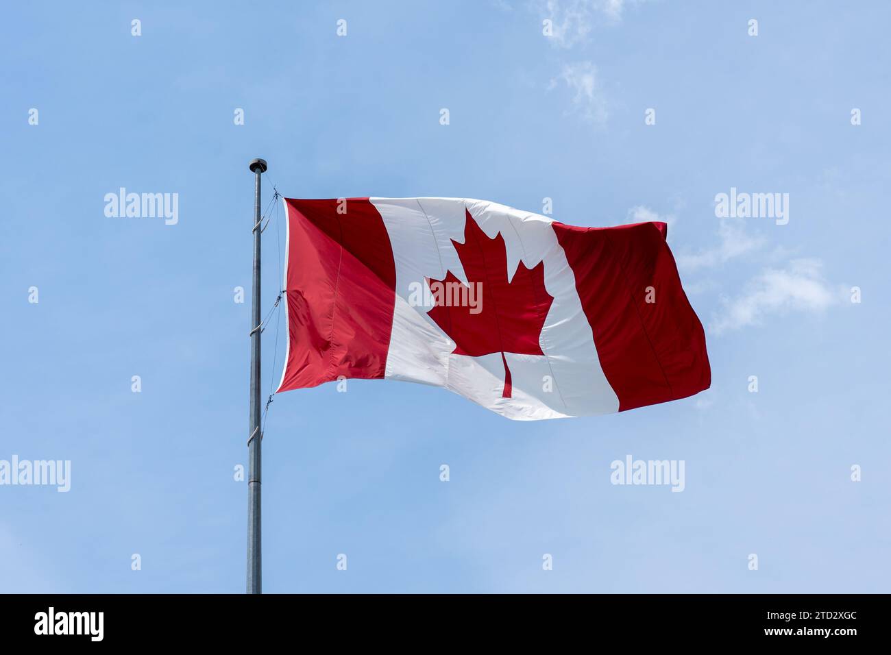 Canadian flag with blue sky in background Stock Photo - Alamy