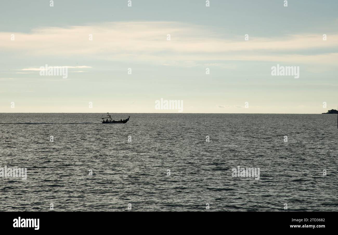 boat sailing along the distance ocean in the horizon Stock Photo - Alamy