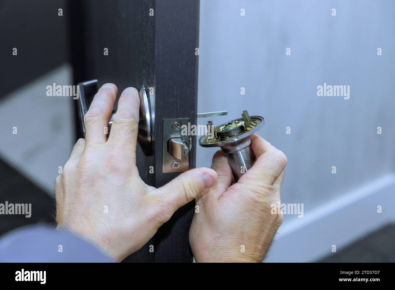 Mechanic installs lock handles on room doors at new house Stock Photo ...
