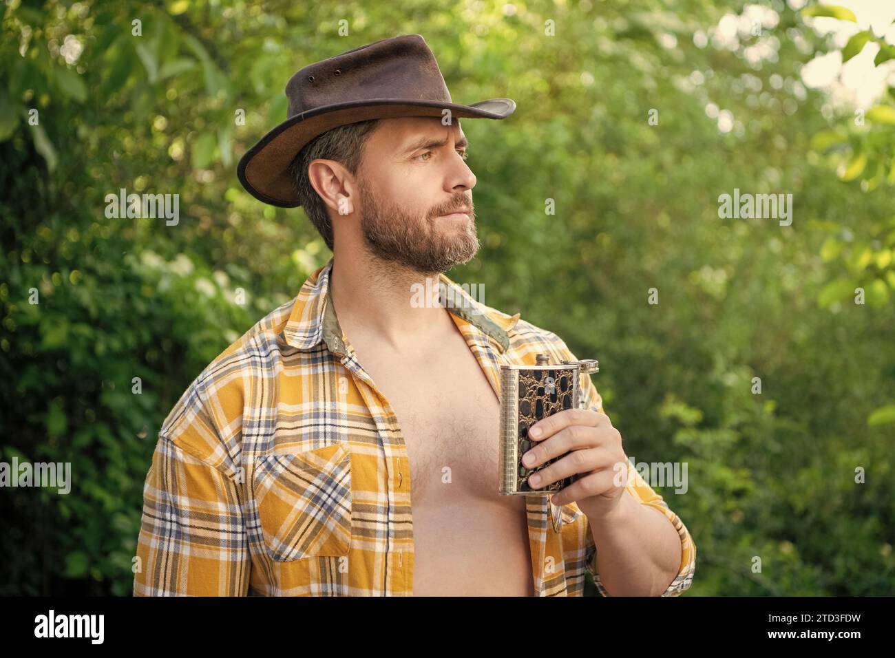 masculine cowboy with flask outdoor. masculine cowboy with flask wear ...