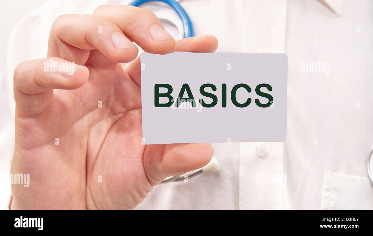 BASICS word on the card in a man's hand on the background of a white ...