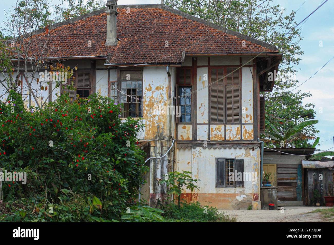 An old brick farm house building with a barn in the background, and ...