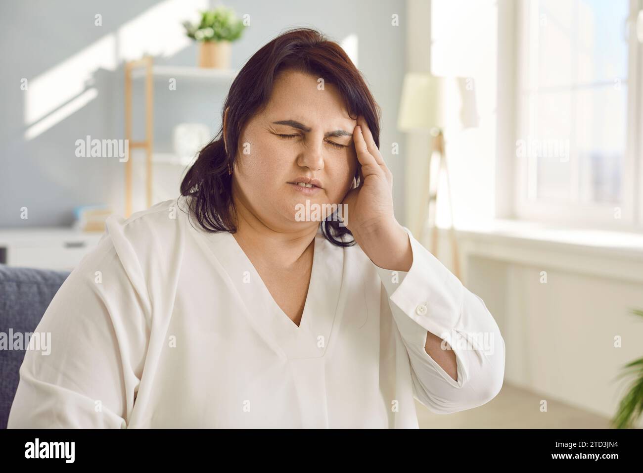 Overweight woman suffering from sudden attack of headache or dizziness ...