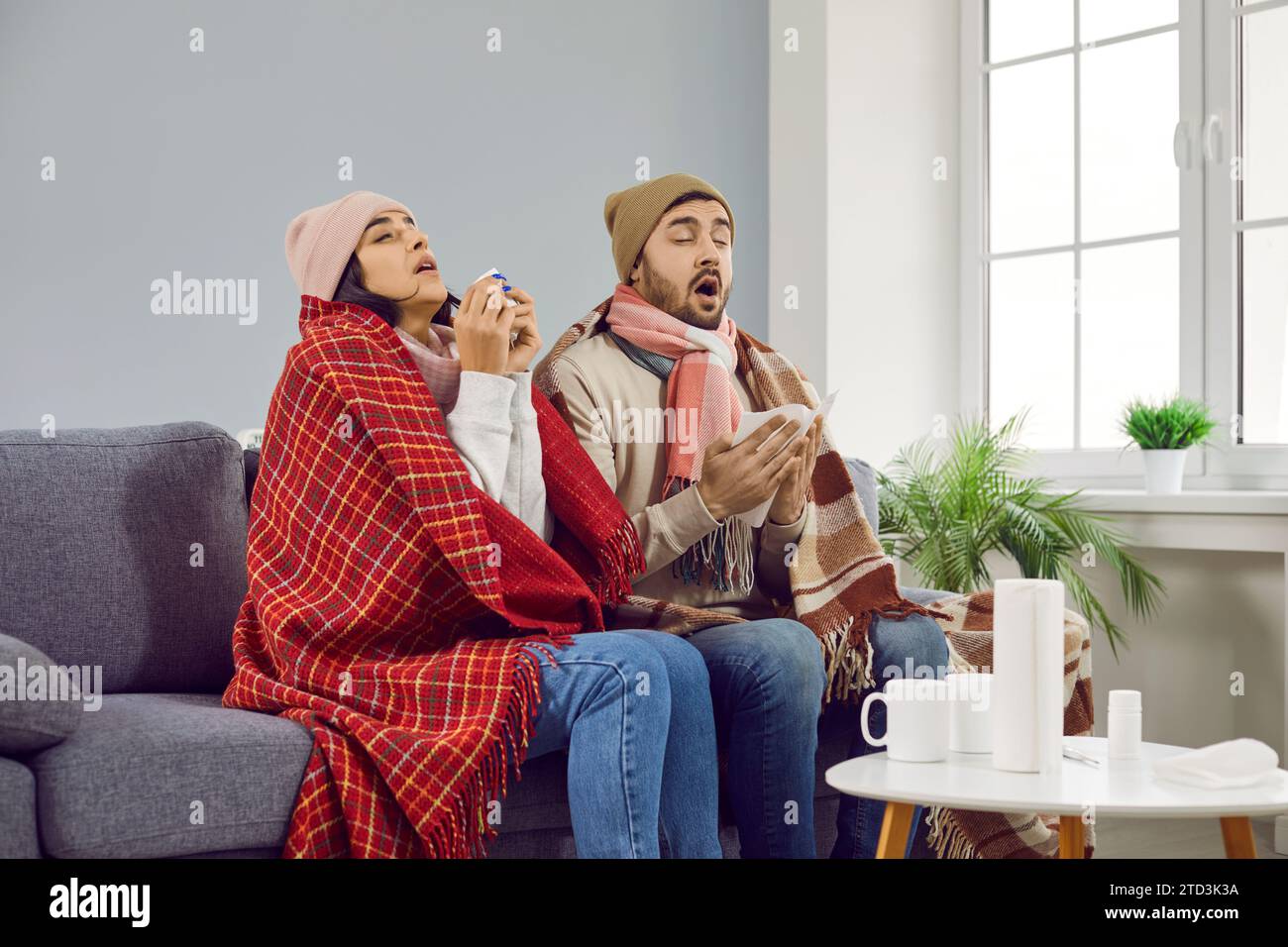 Sick couple covered with blankets suffering from common cold and flu at ...