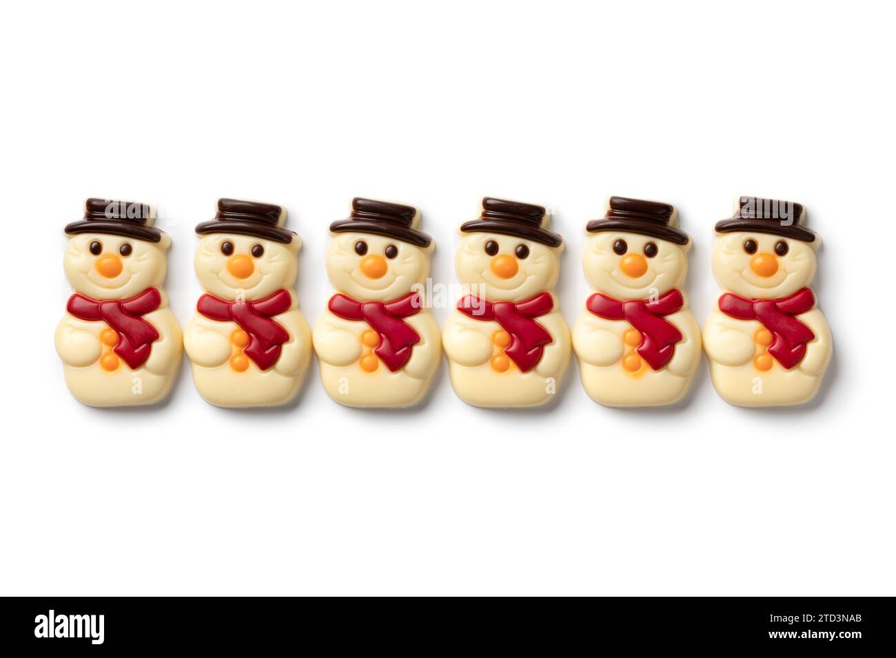 Happy white chocolate snowmen in a row on white background close up ...