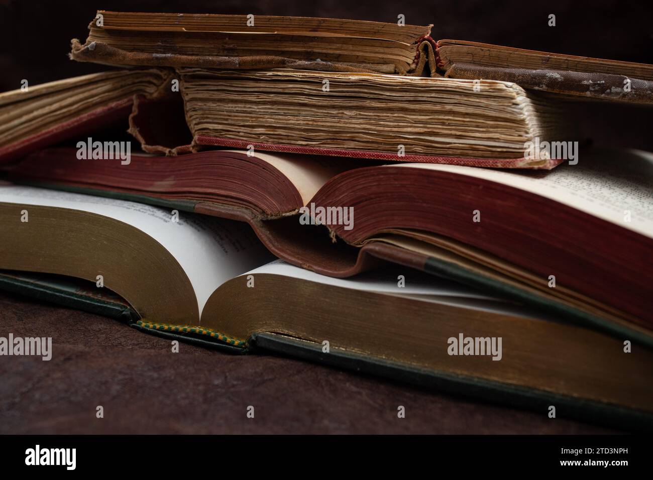 Stack of vintage opened books on leather desk, vignette soft focus ...
