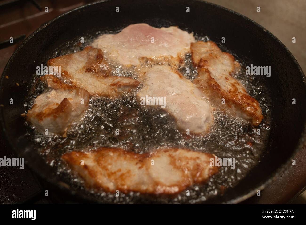 Pork meat boiling in oil, soft focus Stock Photo - Alamy
