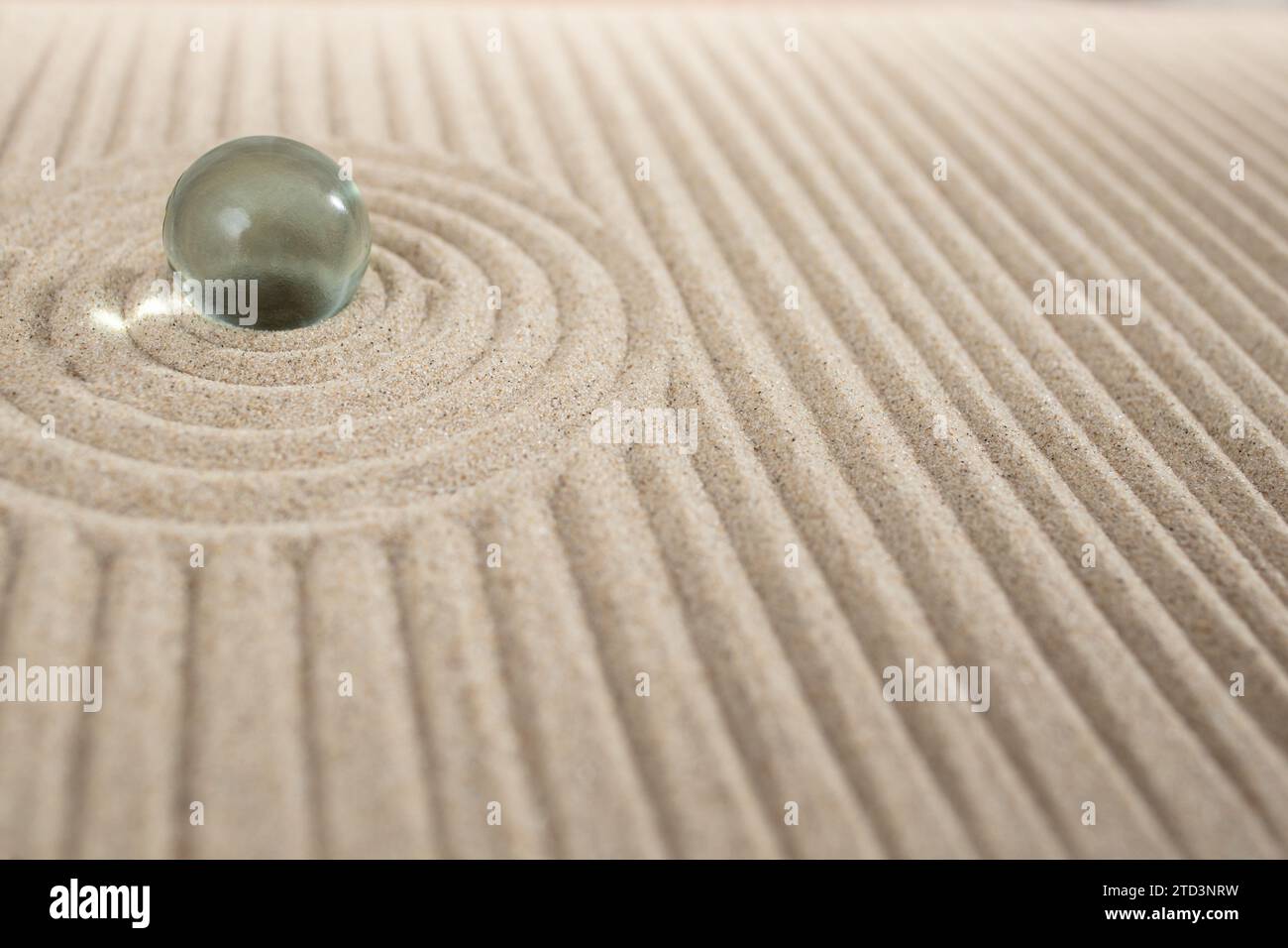 Miniature sand zen garden with a glass sphere and geometric dunes ...