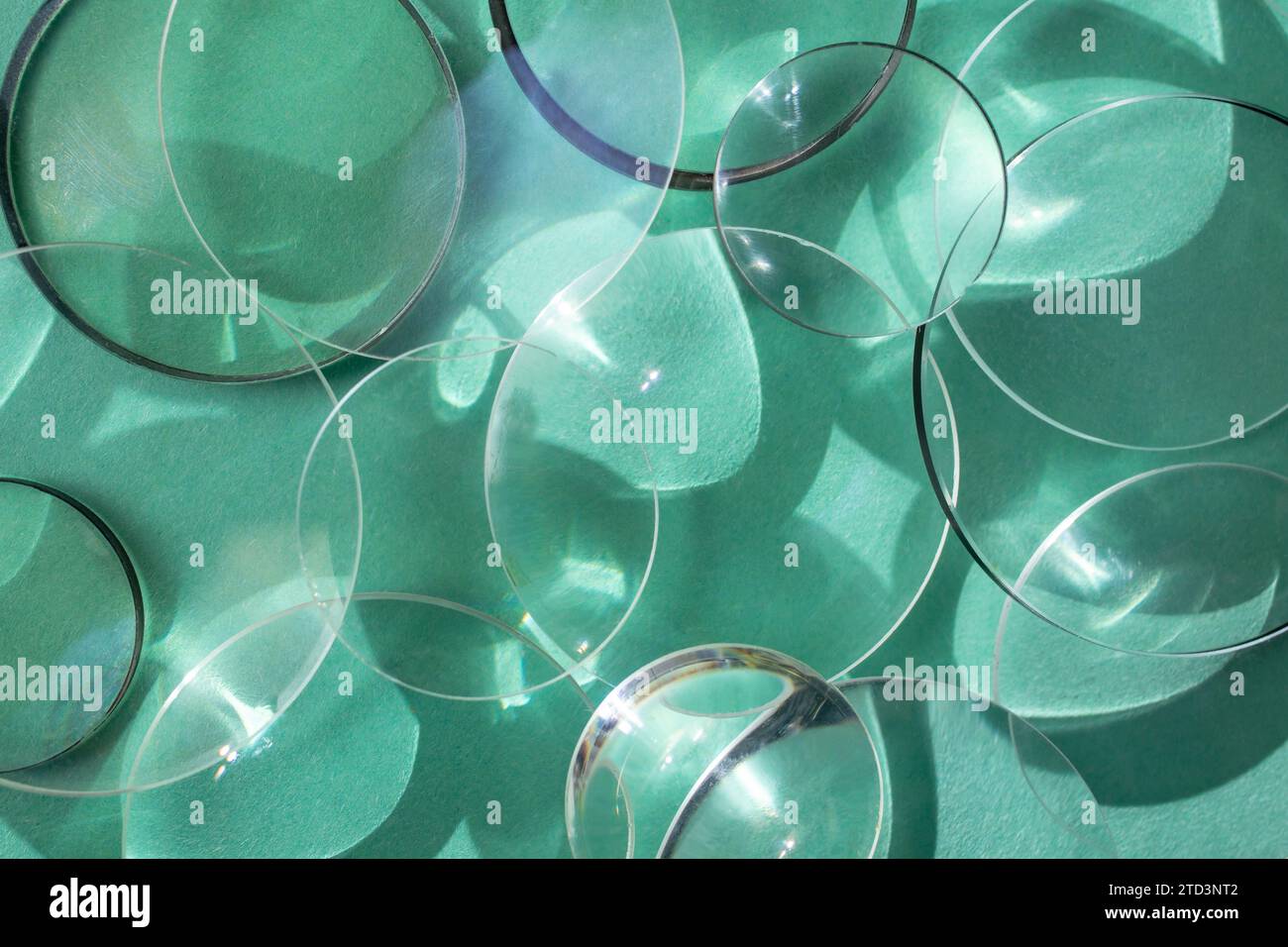 Clear glass round magnifying lenses on turquoise color paper , with ...
