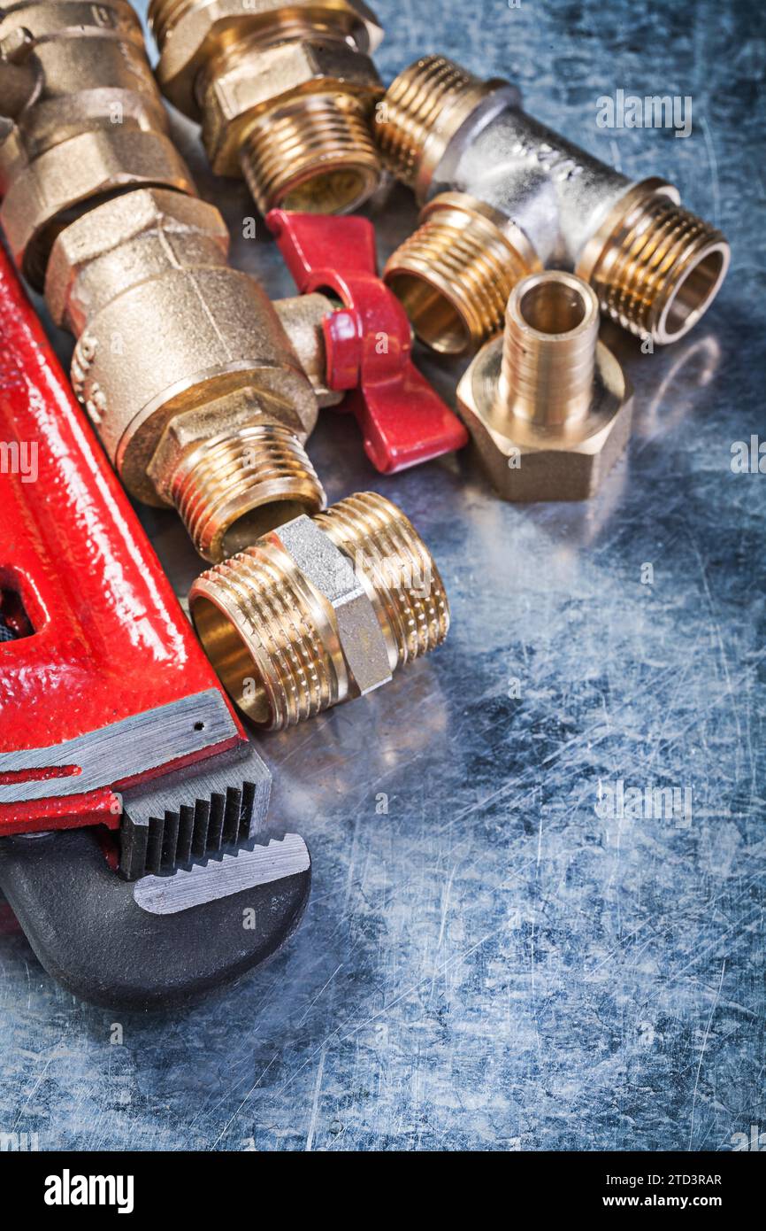 Composition of plumbing hardware on scratched metallic background ...