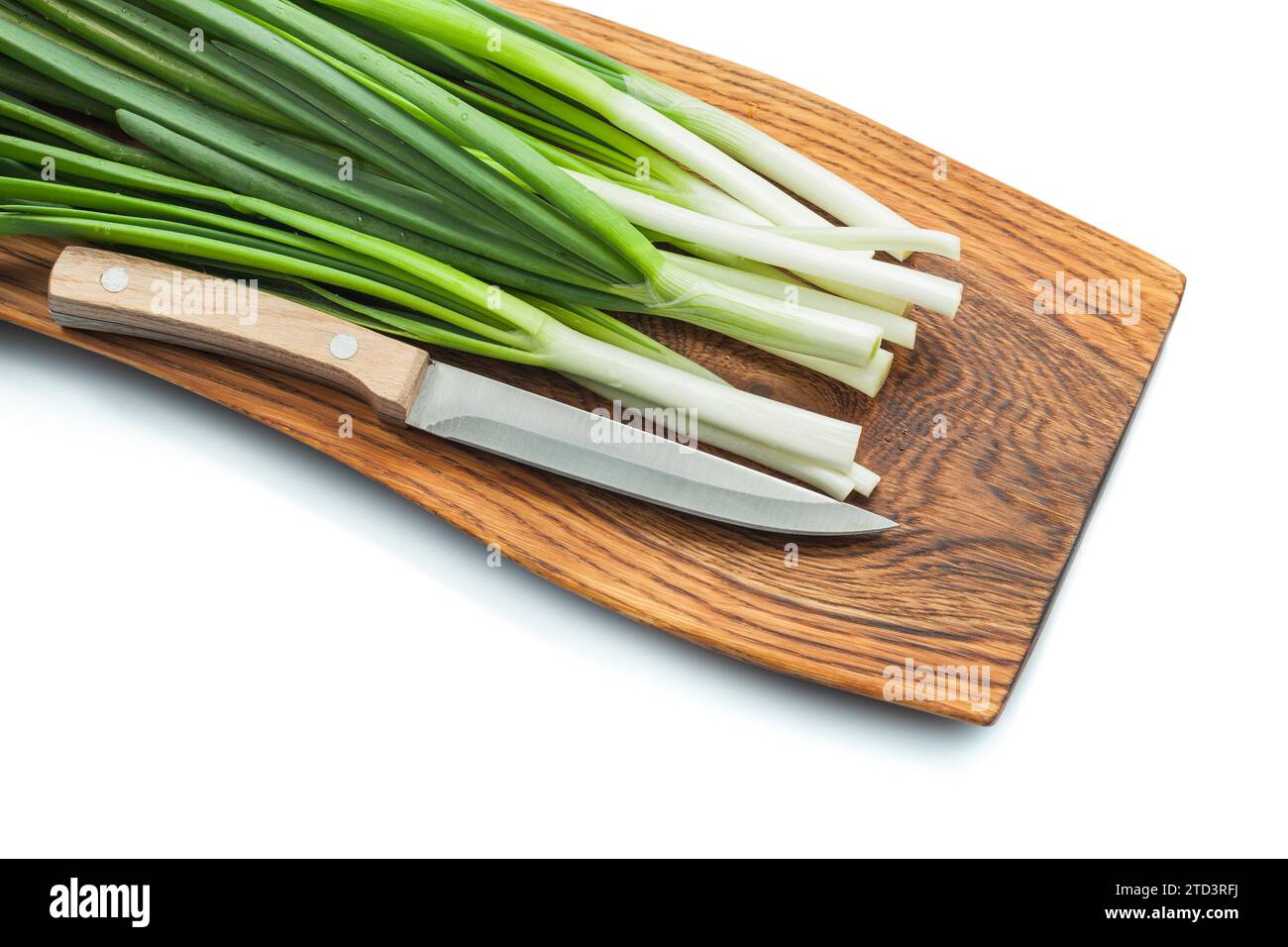 Green spring onion scallion stems with kitchen knife on wooden cutting ...
