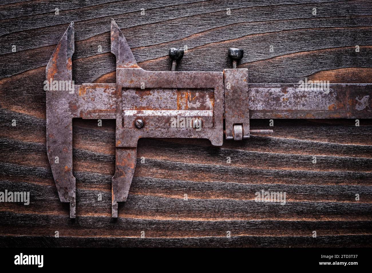 Rusted antique measuring slide caliper on vintage wooden board ...