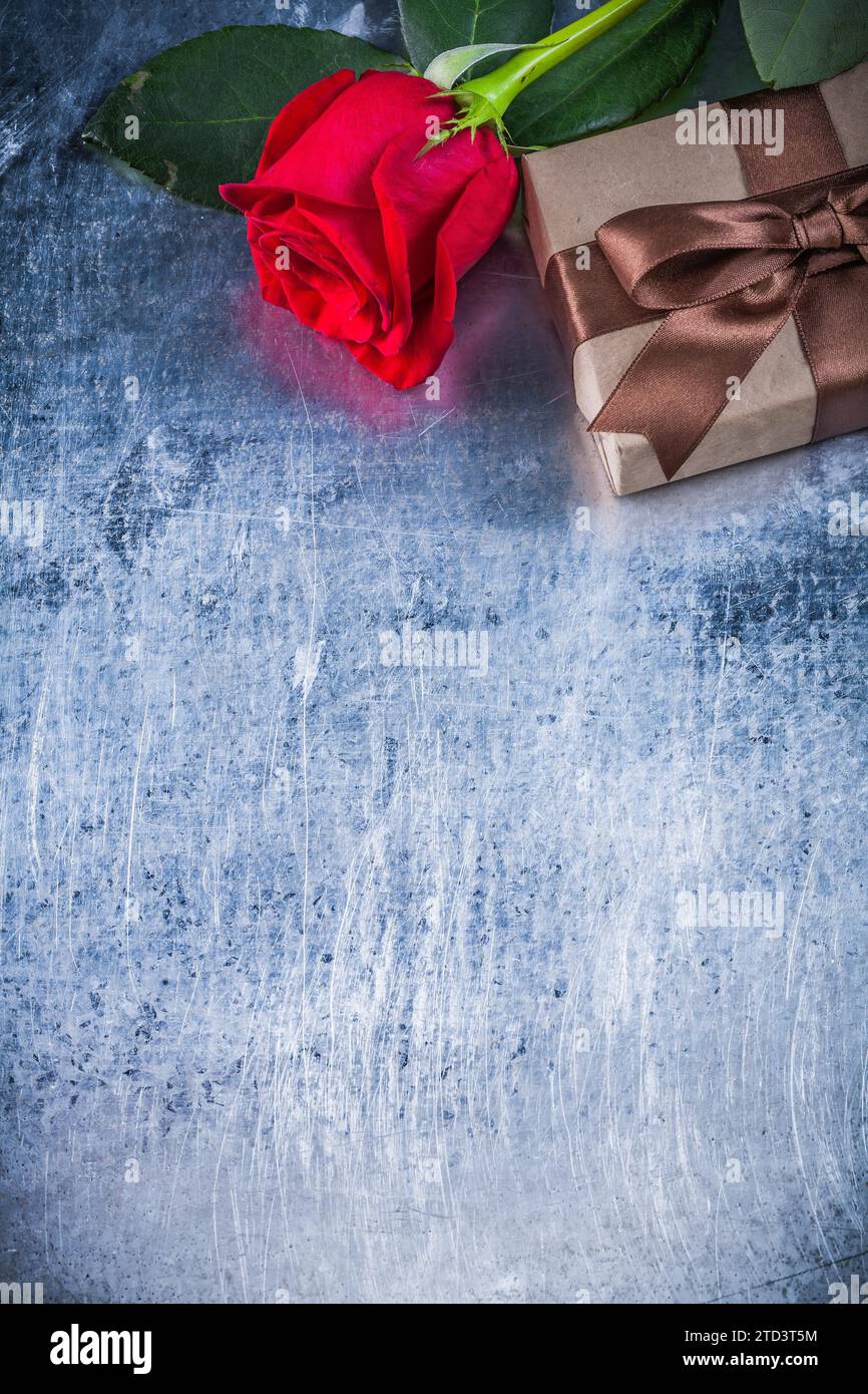 Red rose present box on scratched metallic background holiday concept ...