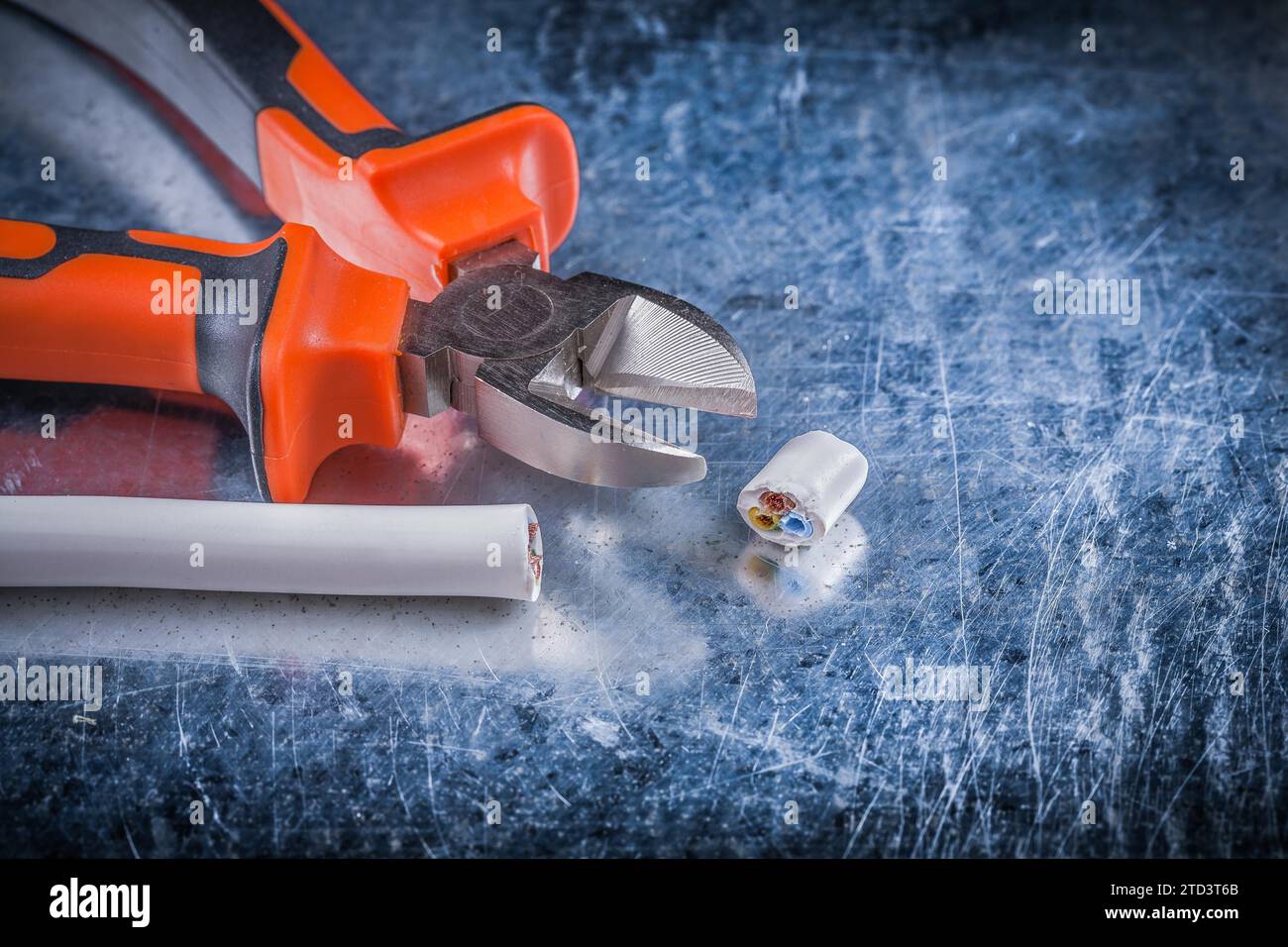 Cutting pliers electrical cable on scratched metallic background ...